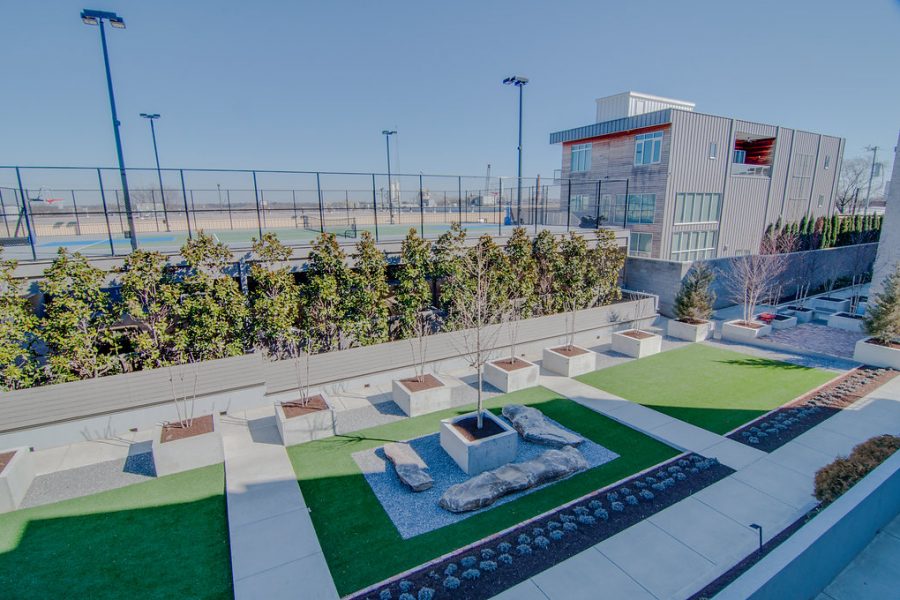 A modern apartment building with a courtyard and tennis courts ...